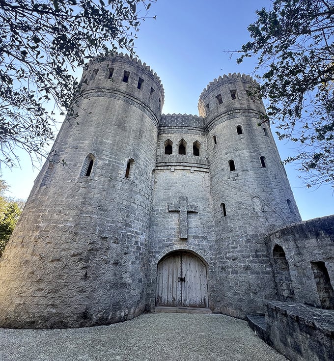 Front-facing majesty! The castle's imposing façade features twin towers and a prominent cross, blending medieval architecture with spiritual symbolism.