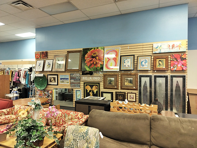 Wall art paradise where a "Be Kind" sign nestles among floral paintings and cityscapes. Someone's perfect statement piece is hiding in plain sight.