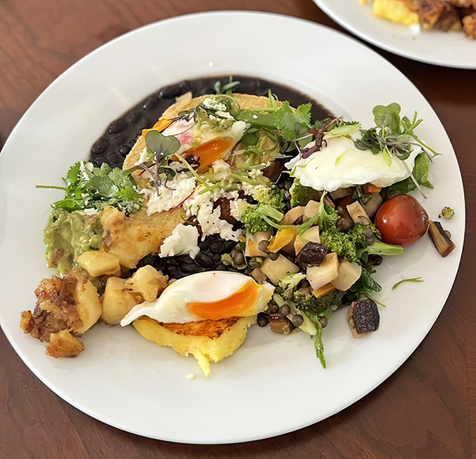 A fiesta on a plate! Black beans, fresh greens, eggs, and what appears to be perfectly ripe avocado—breakfast with no passport required.