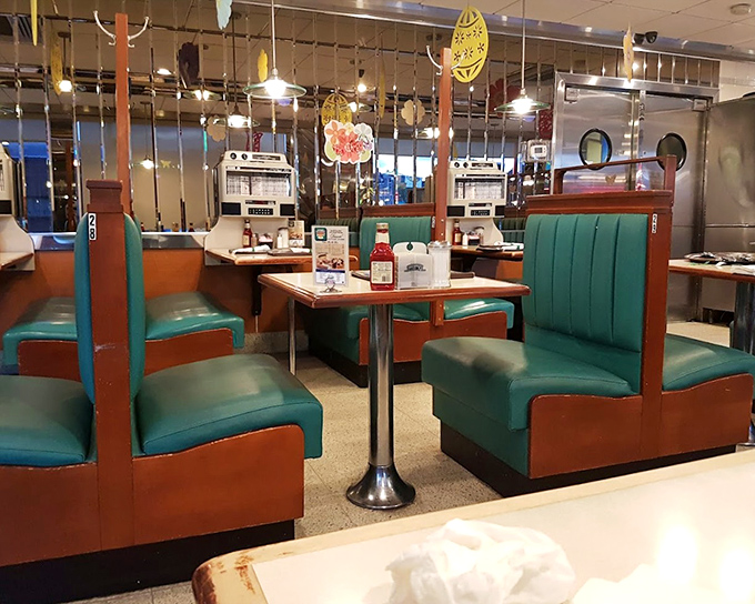The turquoise booths and retro dividers aren't just seating—they're time machines to when conversation and comfort food were life's greatest luxuries.