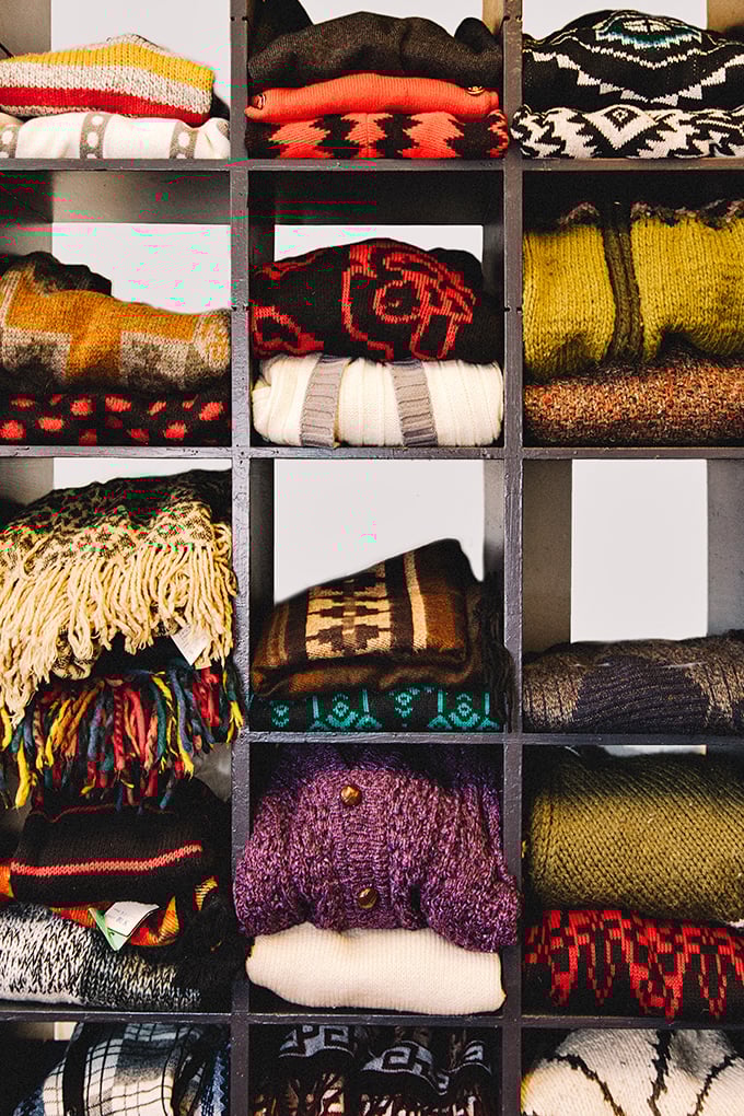 Cozy knits stacked like a textile library. Each sweater pattern tells the story of a different decade's approach to staying warm with style.