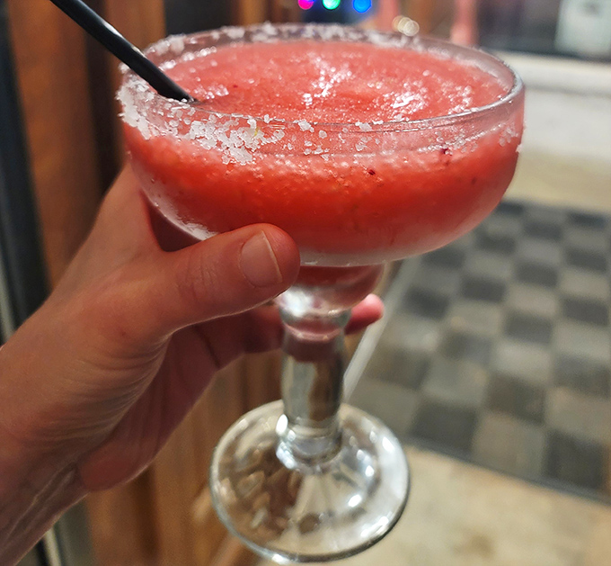 A frozen margarita with a salt rim sitting pretty—because sometimes pizza night calls for a little liquid celebration.