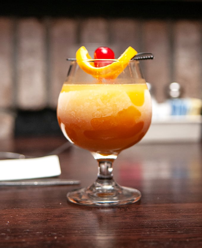 This isn't just a cocktail—it's liquid sunshine in a glass, garnished with citrus and cherry for that perfect "I deserve this" moment.