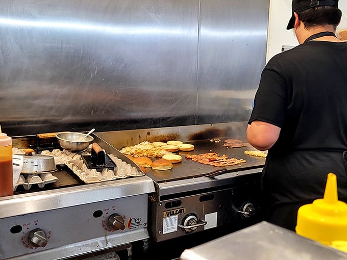 The open kitchen isn't just functional—it's dinner theater where short-order cooks perform culinary magic inches from your appreciative gaze.