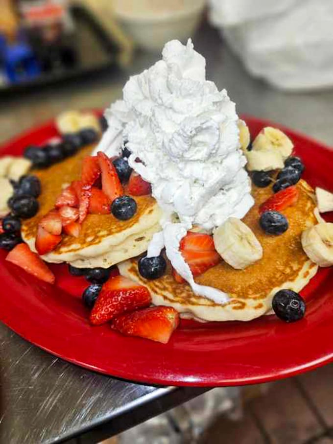 Pancakes wearing their finest fruit jewelry and a whipped cream hat. This stack isn't breakfast—it's an event your fork has been training for.