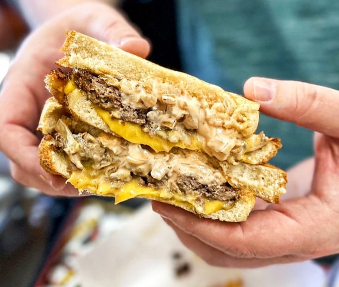 The cross-section of a perfect patty melt reveals the holy trinity: melted cheese, caramelized onions, and beef cooked just right.