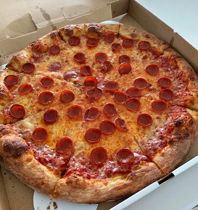 Pepperoni that curls into perfect little flavor cups, holding precious pools of savory oil. This isn't just pizza—it's edible architecture with purpose.