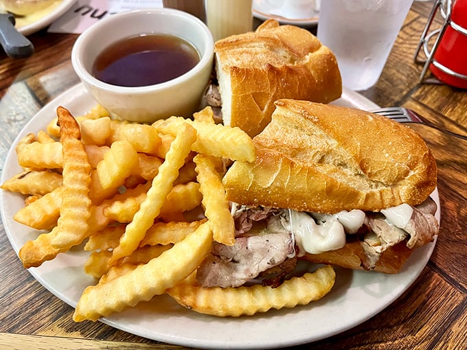 The French dip sandwich—where beef and bread find their higher purpose. Those fries aren't just a side; they're crispy golden co-stars in this comfort food production.