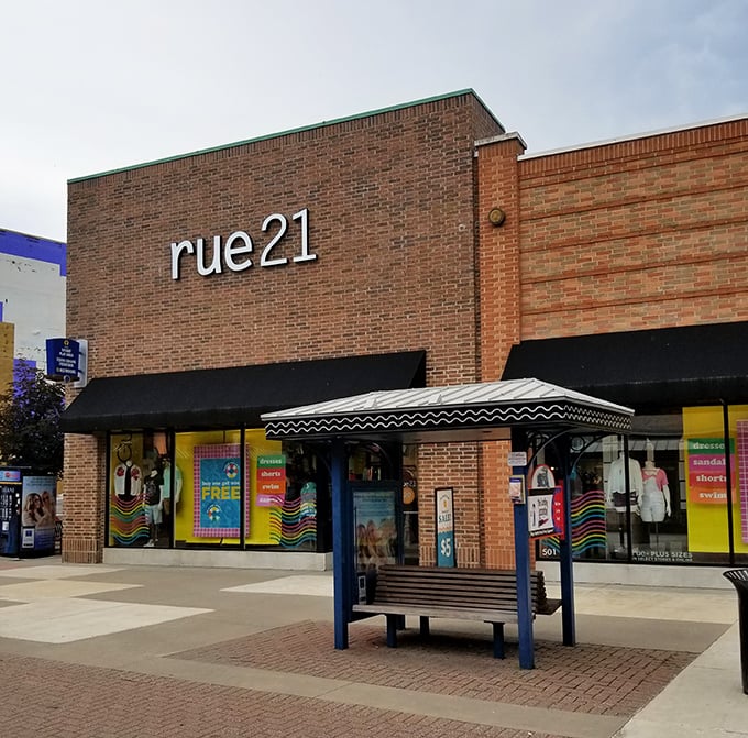 Rue21's vibrant display windows pop with youthful energy. That covered bench isn't just seating—it's a strategic resting spot for planning your next retail assault.