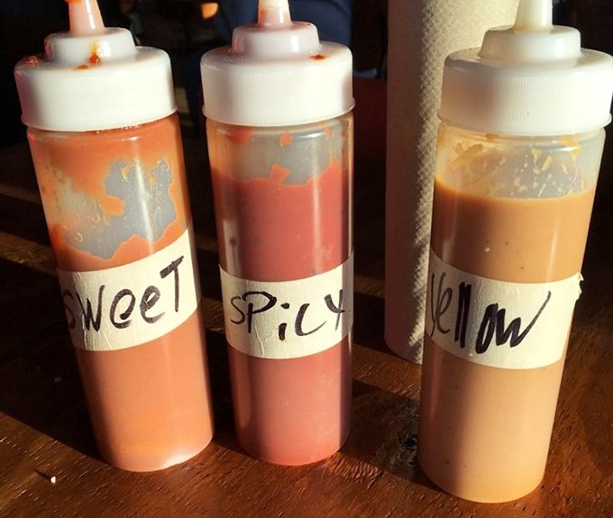 Three sauces labeled simply as "Sweet," "Spicy," and "Yellow" – because when you're this confident in your barbecue, you don't need fancy names.