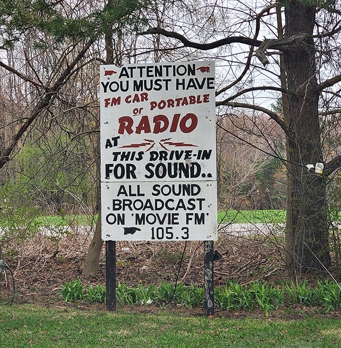 The handwritten sign says it all—FM radio required for sound, just as drive-in gods intended since abandoning those clunky window speakers.