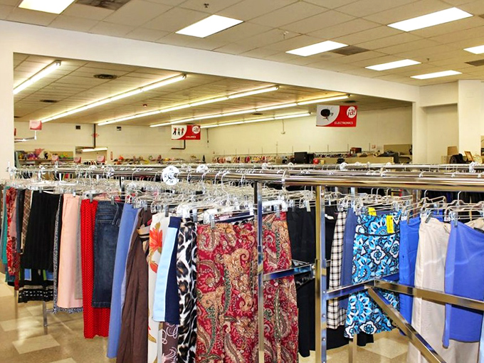 Racks of colorful clothing create a textile rainbow. Each garment holds the potential to become someone's "you won't believe where I found this" story.