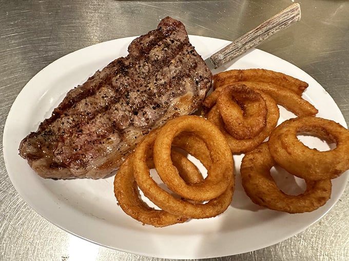 A perfectly seared steak with golden onion rings—proof that Lou's dinner game is just as strong as its breakfast reputation.