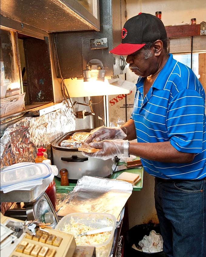 Craftsmanship in motion – skilled hands preparing each sandwich with the precision and care that comes from generations of barbecue wisdom.