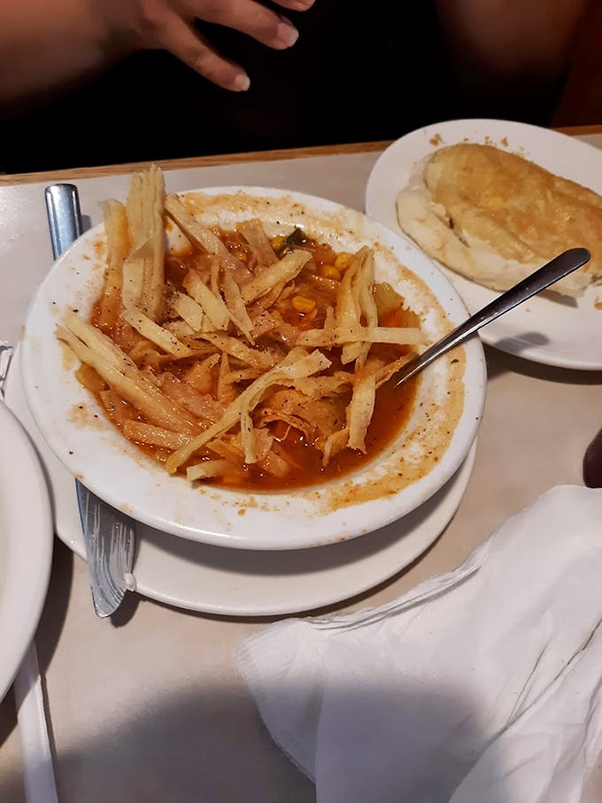 Tortilla soup with enough strips to build a small shelter, swimming in a broth so flavorful it should have its own fan club.