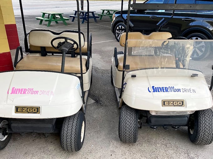 The humble golf carts—unsung heroes of the drive-in experience—ready to guide latecomers to the perfect viewing spot.
