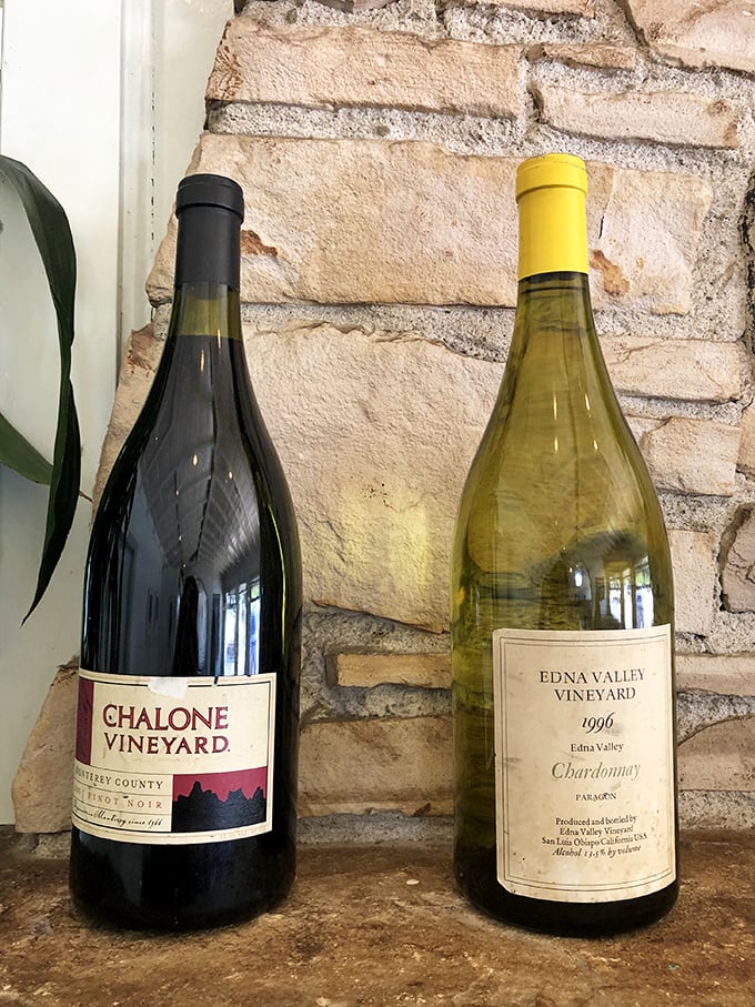 Wine bottles that patiently wait their turn to enhance your seafood experience—like supporting actors who know exactly when to step into the spotlight.