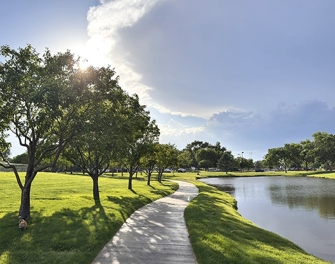 A peaceful afternoon walk in Fort Morgan offers sunshine, calm waters, and a quiet escape surrounded by lush green beauty.