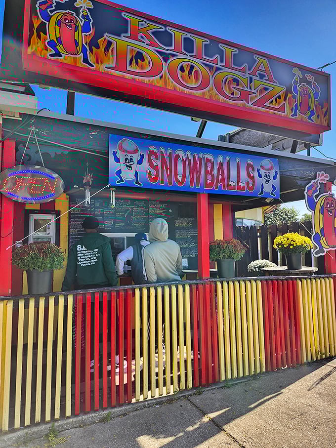 The vibrant storefront of Killa Dogz serves both hot dogs and snowballs – a one-stop shop for all your summer cravings.