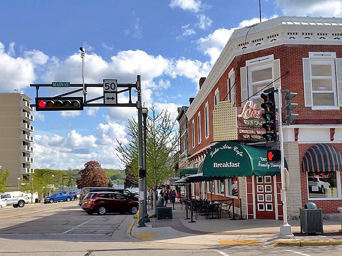 Corner café culture! Lake Geneva's brick-and-awning ensemble plays host to morning coffee rituals where locals and tourists mingle under the watchful eye of that traffic light.