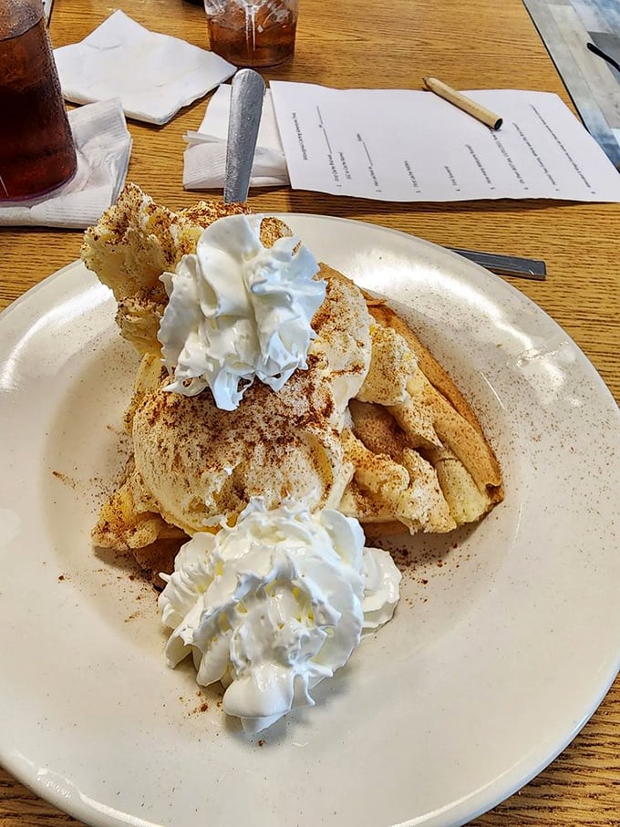 This isn't just French toast—it's a cloud of cinnamon-dusted heaven topped with enough whipped cream to make your cardiologist wince.