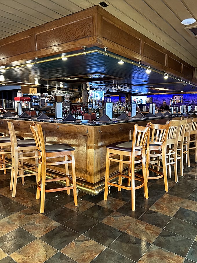 The bar area gleams with polished wood and ambient lighting—a captain's quarters where maritime tales and craft cocktails flow freely.
