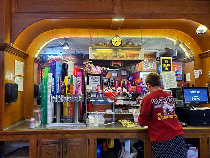 The bar area – where Oklahoma sports memorabilia meets cold drinks. This is command central for the chicken operation that's kept locals happy for generations.