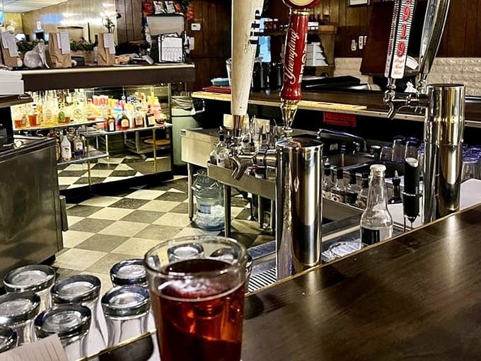 The bar area invites you to pull up a stool and settle in. Notice the classic checkered floor—no design consultant needed, just timeless appeal.