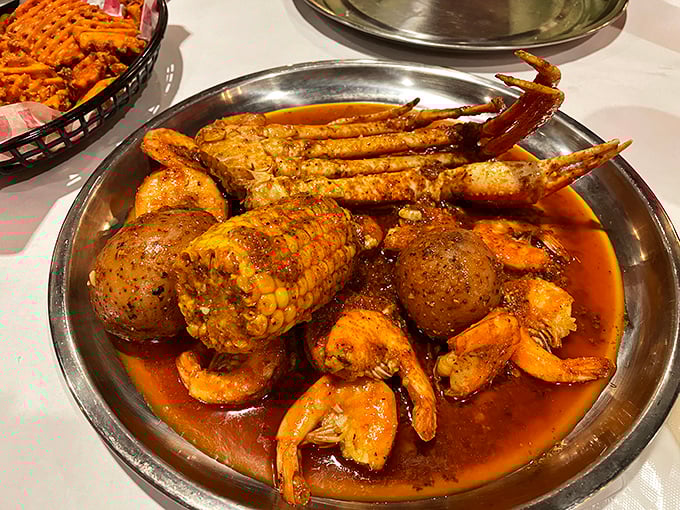A metal bowl brimming with seafood and spice—where crab legs stretch out like they're lounging at a five-star resort in butter sauce.
