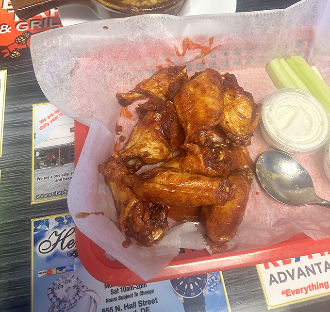 These wings aren't just cooked – they're coaxed to perfection, glistening with sauce that promises to leave evidence of your indulgence on at least three napkins.