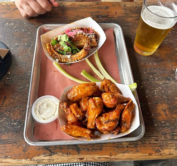 Wings and onion rings sharing a tray like old friends at a reunion – crispy, saucy, and ready to disappear faster than fog in sunshine.