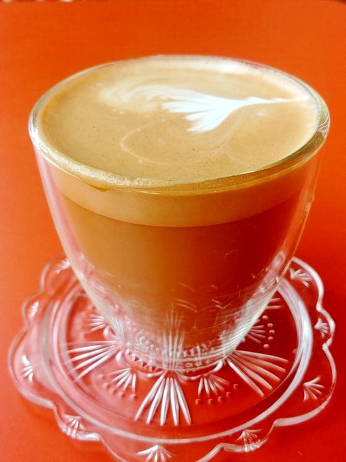 The cortado sits regally on its crystal throne—the perfect ratio of espresso to milk, creating liquid velvet in a glass.