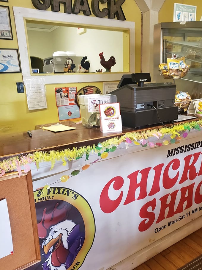 Chicken figurines stand guard at the counter, overseeing quality control. The colorful Easter-like garland adds a touch of perpetual celebration.