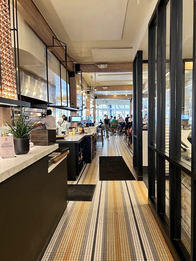 The marble counter offers front-row seats to the culinary performance, where dough becomes art before your very eyes.