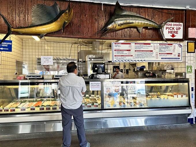 The ordering counter with trophy fish overhead—where dreams of fresh seafood become delicious reality.
