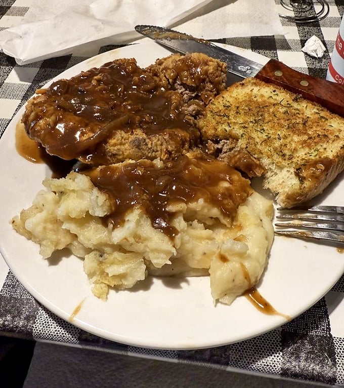Country fried steak swimming in gravy with a side of mashed potatoes – comfort food that hugs you from the inside out.
