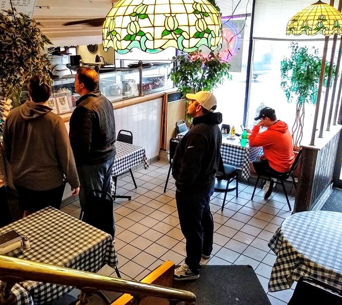 The lunch rush at Mama's—where locals patiently wait for sandwich greatness. That stained-glass lamp has witnessed thousands of first-bite expressions of pure joy.
