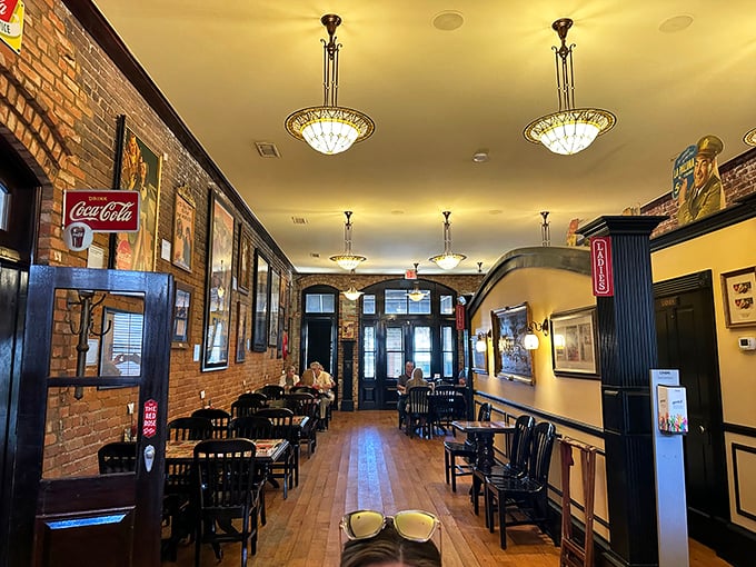 The dining area whispers stories of decades past through exposed brick walls and elegant chandeliers—casual elegance with a Southern drawl.