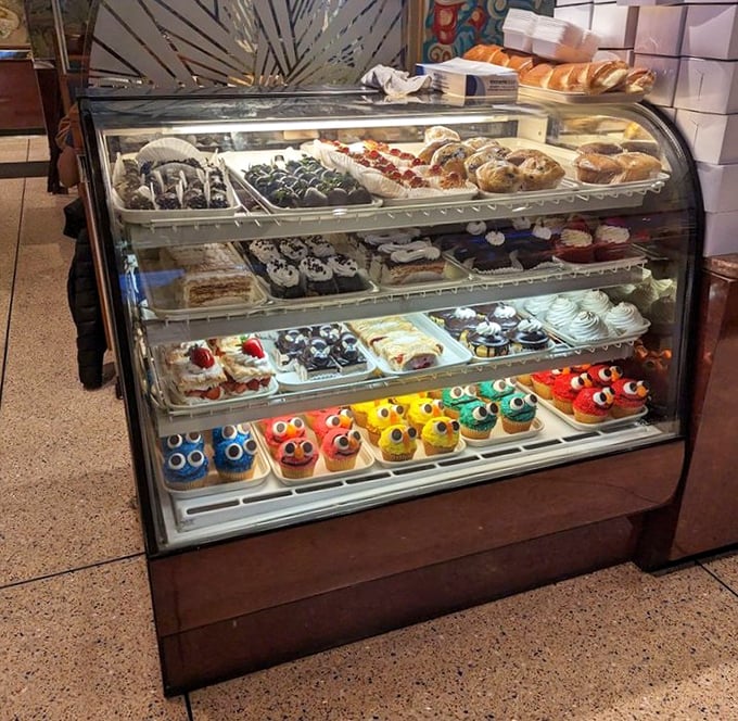 The dessert case—where willpower goes to die and happiness begins. Those colorful cupcakes with googly eyes are practically begging to be adopted.