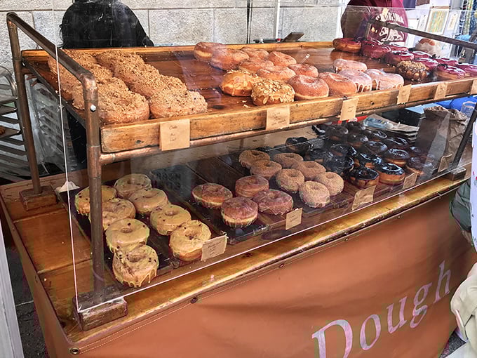 The Dough display case—where willpower goes to die. These artisanal donuts make waiting in line a spiritual practice worth every minute.