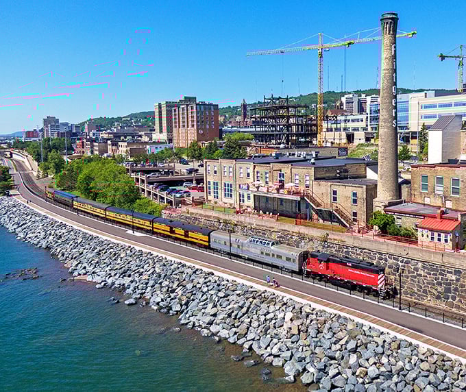 The cityscape unfolds as the train hugs the shoreline – Duluth's industrial heritage and natural beauty creating a uniquely Minnesotan tableau.