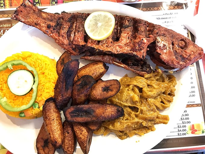 Whole grilled fish with fried plantains and that signature onion sauce—this is how coastal Senegal does seafood right.