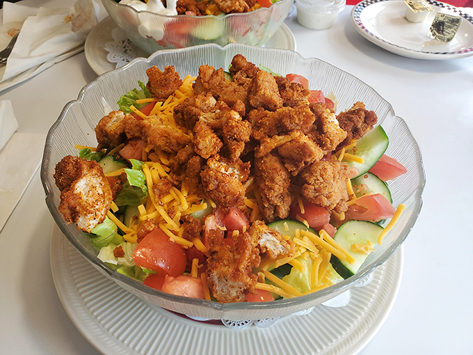 Crispy chicken perched atop a garden of fresh vegetables and cheese—proof that "salad" can be both virtuous and indulgent.