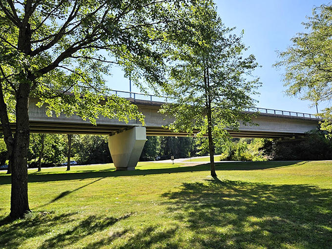 The bridge casts geometric shadows across manicured lawns – a perfect marriage of human design and natural beauty.