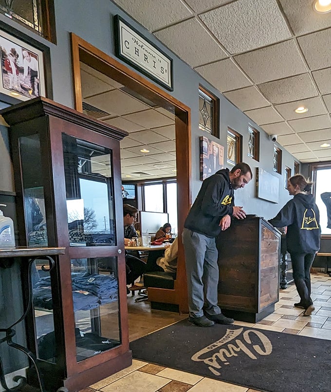 The host station, with its wooden warmth and "Welcome to Chris'" floor mat, sets the tone for what awaits: unpretentious hospitality at its finest.