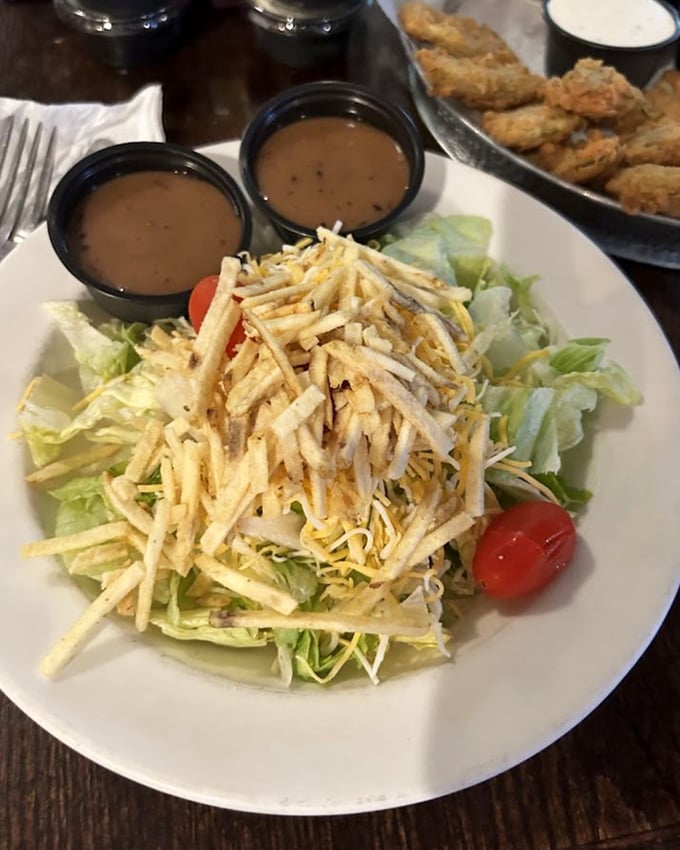 A salad that doesn't apologize for being exactly what it is—crisp lettuce topped with cheese, tomato and those addictive fried catfish strips.