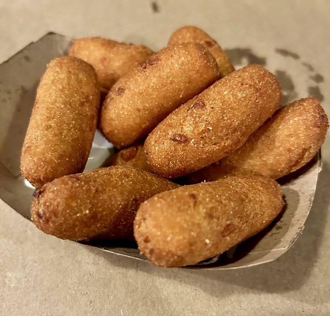 Hush puppies: golden-brown orbs of cornmeal perfection. These aren't just side dishes—they're essential tools for soaking up every last drop of seafood goodness.