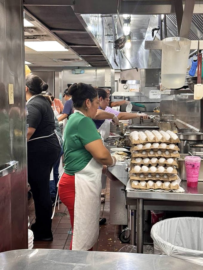 The kitchen ballet—where dozens of eggs meet their destiny each morning. Those stacked cartons represent countless future happy customers.