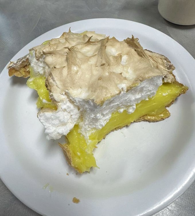 Lemon meringue pie with peaks so high they need their own elevation warning. That golden filling shines brighter than Kansas sunshine.