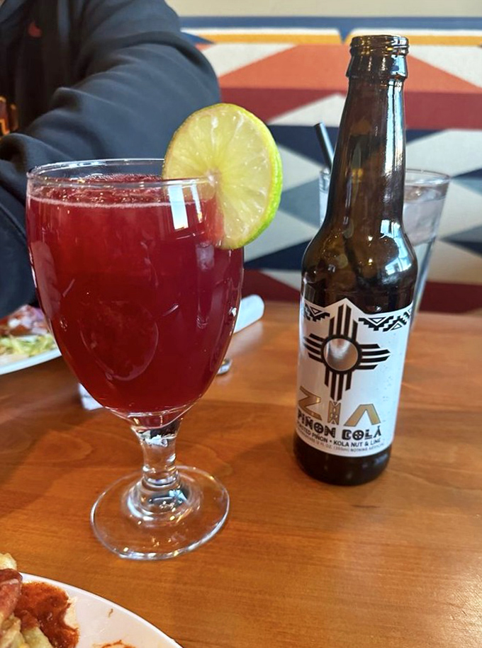 That vibrant red prickly pear mojito isn't just a drink—it's liquid New Mexico, served alongside a Zia-emblazoned soda that screams local pride.